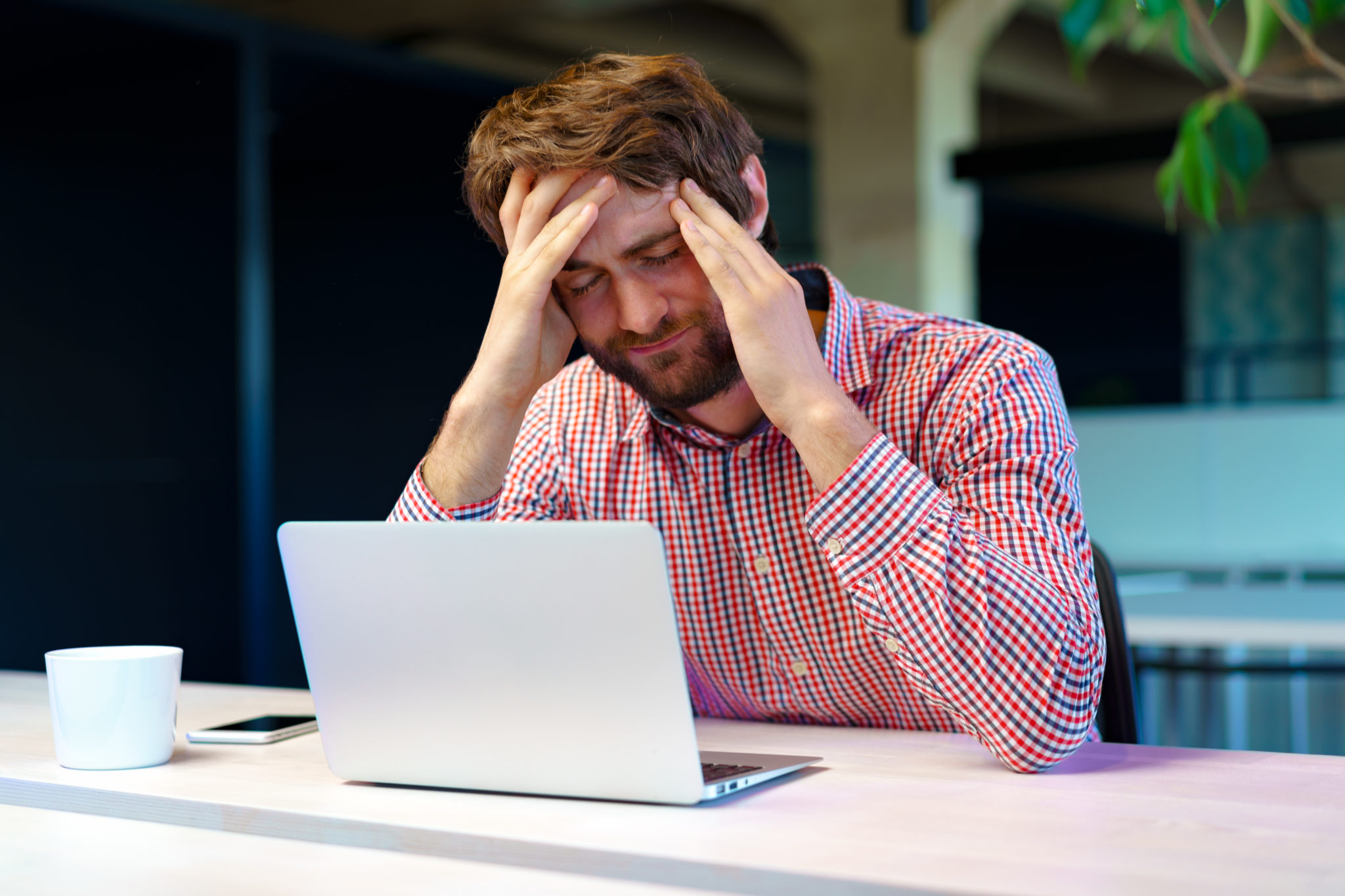 Tired businessman working on his computer in open space office - Agent ...